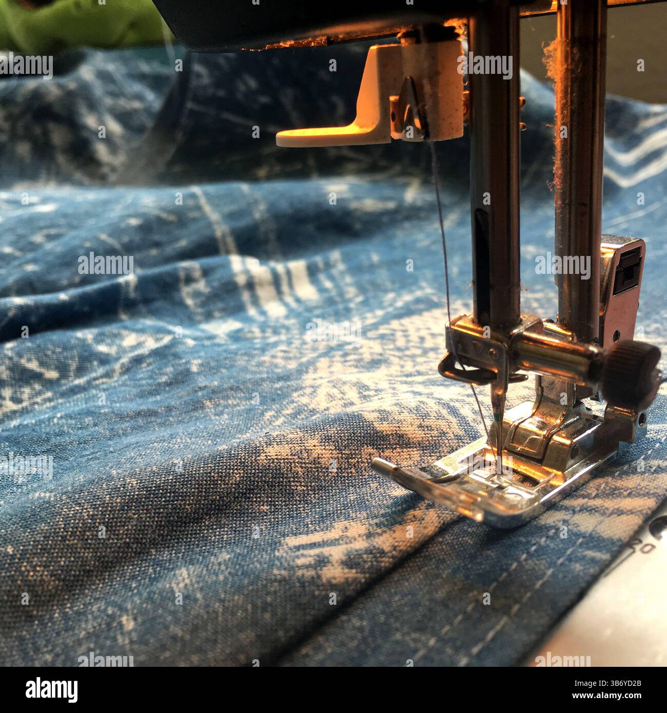 A close-up image of sewing machine's needle and presser foot while ...