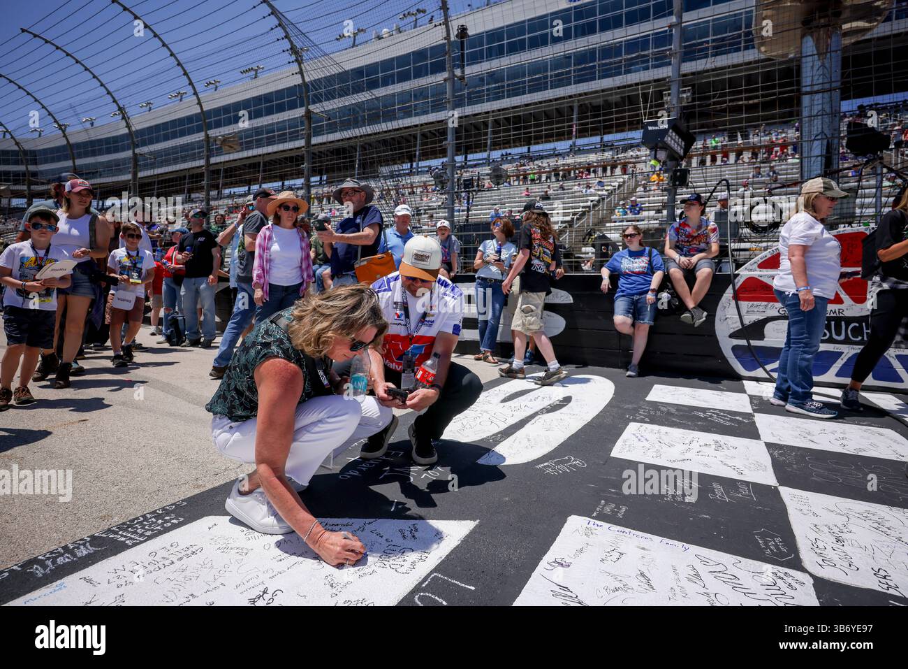 Fans sign the finish line on the track before a NASCAR Cup Series auto ...