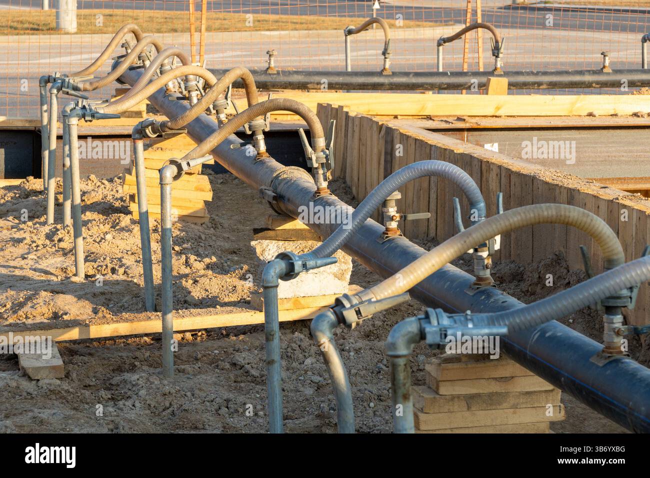 A close-up view of a series of flexible hoses connected to a pipe at a ...