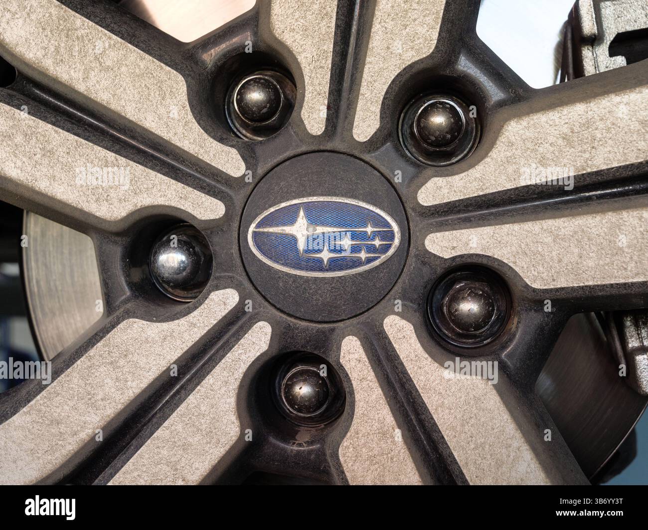 Dirty alloy wheel displaying Subaru logo, lug nuts revealing vehicle ...
