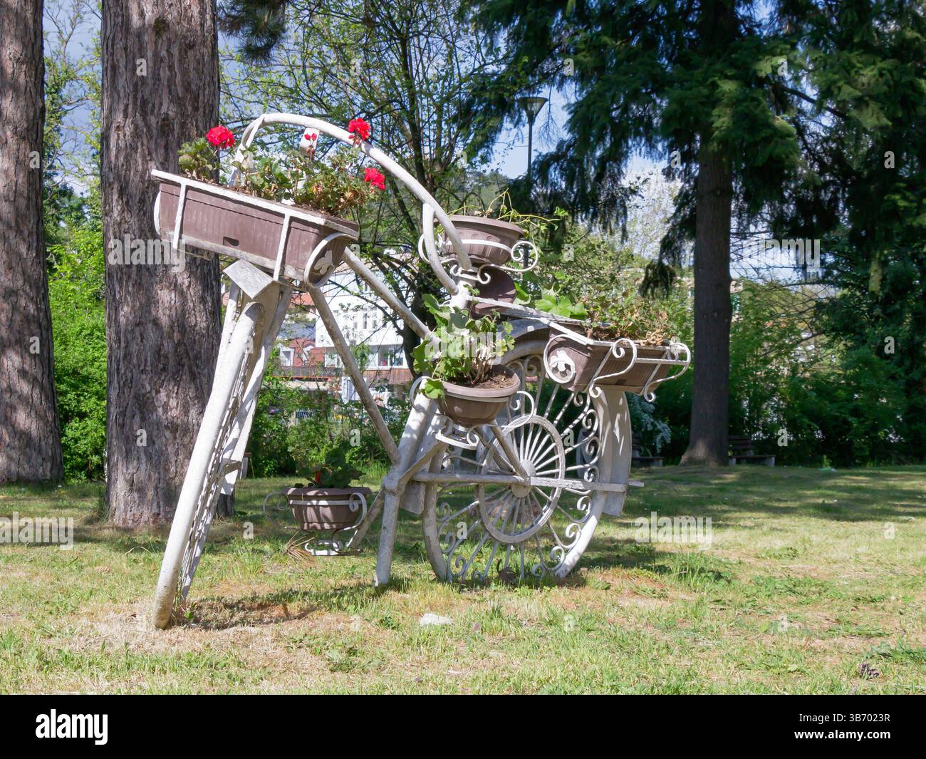 A creative bicycle sculpture features vibrant flower pots and greenery ...