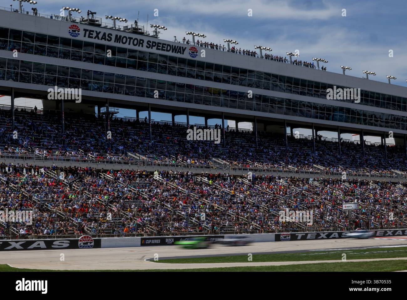 Fans watch as Christopher Bell, bottom left, drives by during a NASCAR ...