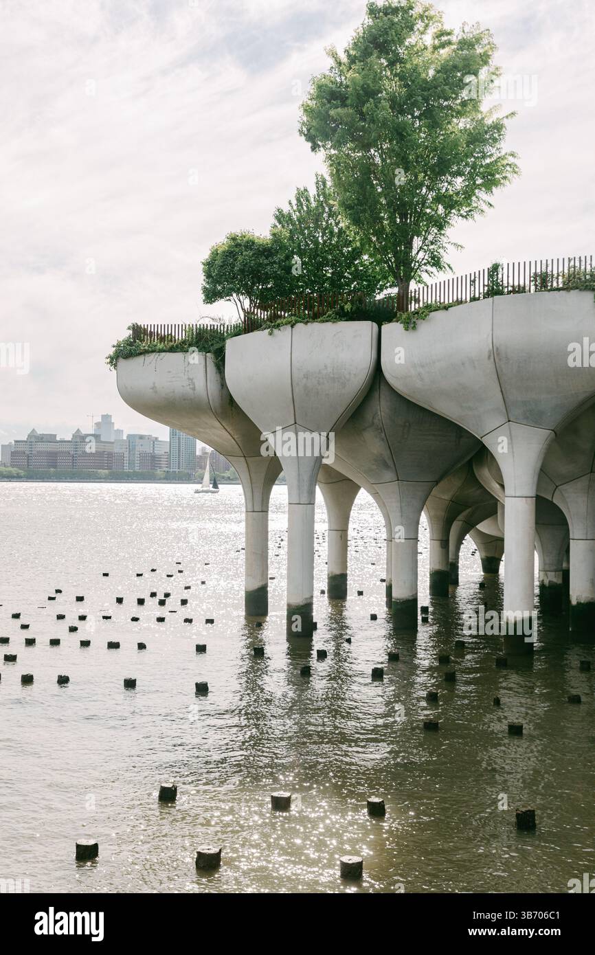 A concrete structure rises above water, adorned with greenery ...