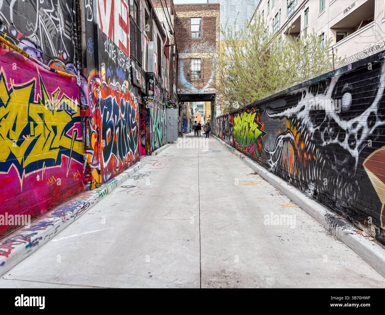Graffiti Alley. Urban alleyway walls covered in vibrant spray paint art ...