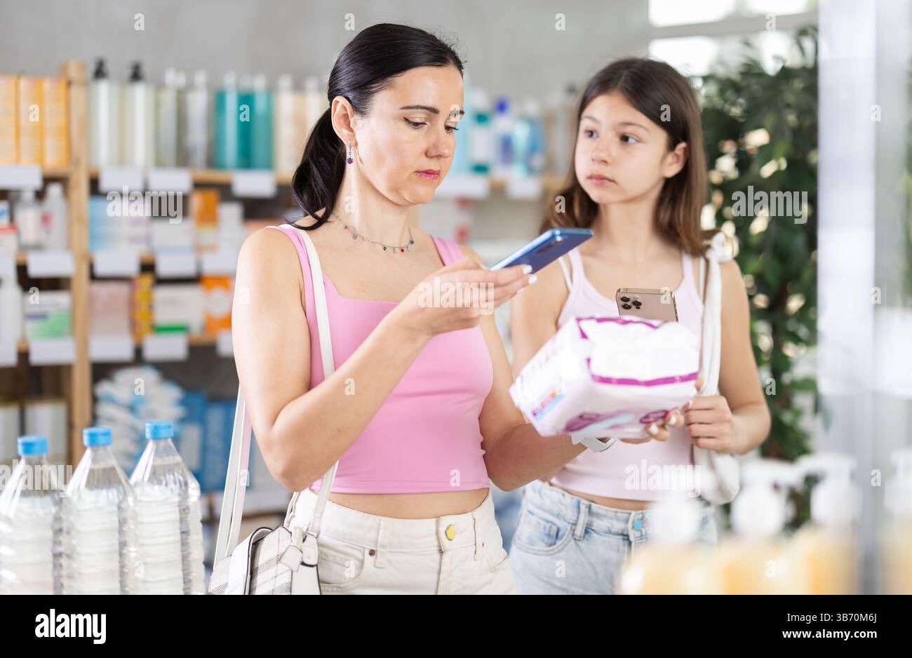 Mom and daughter scanning QR-code on feminine pads in drugstore Stock ...