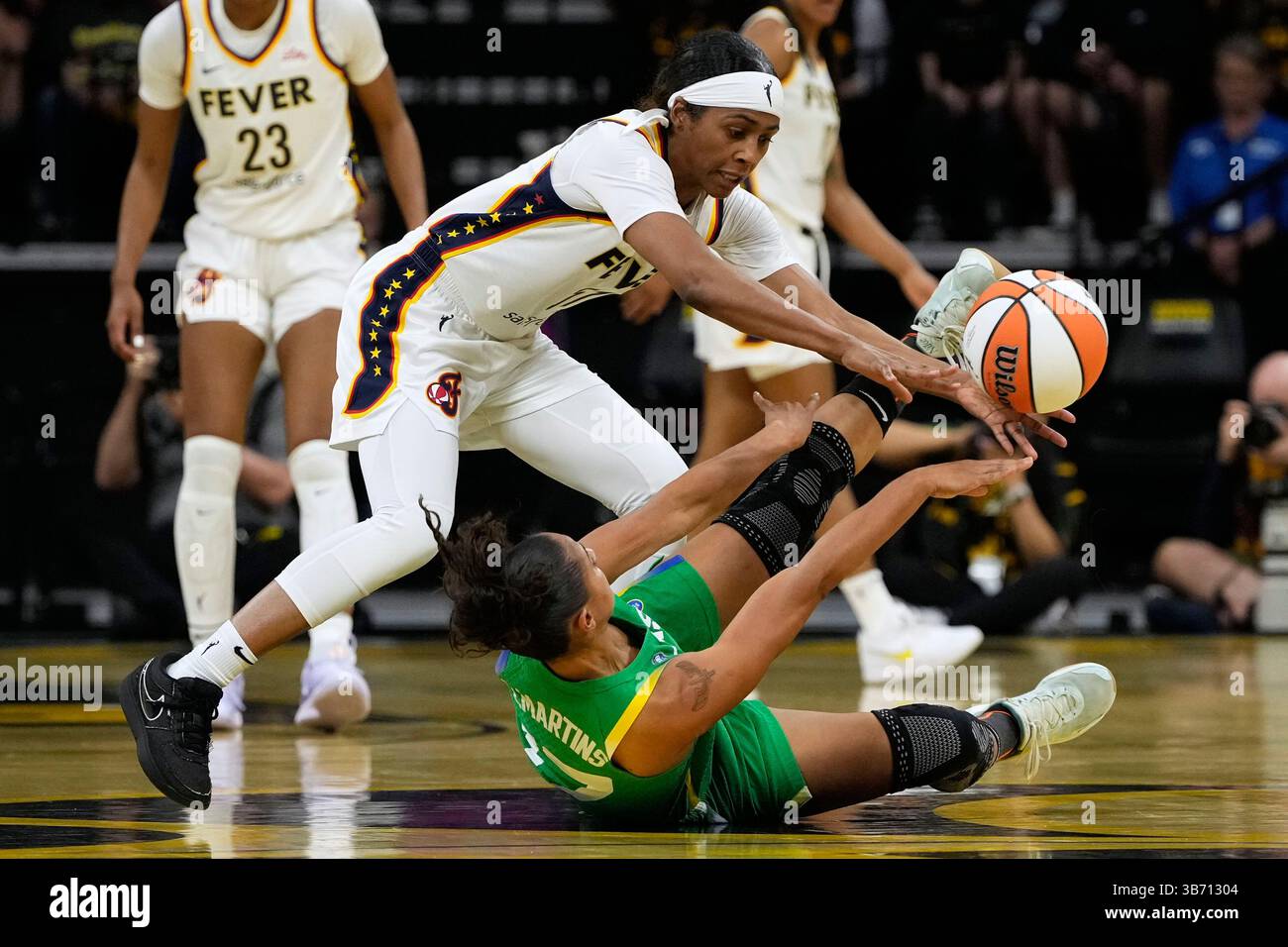 Indiana Fever guard Sydney Colson, left, fights for a loose ball with ...