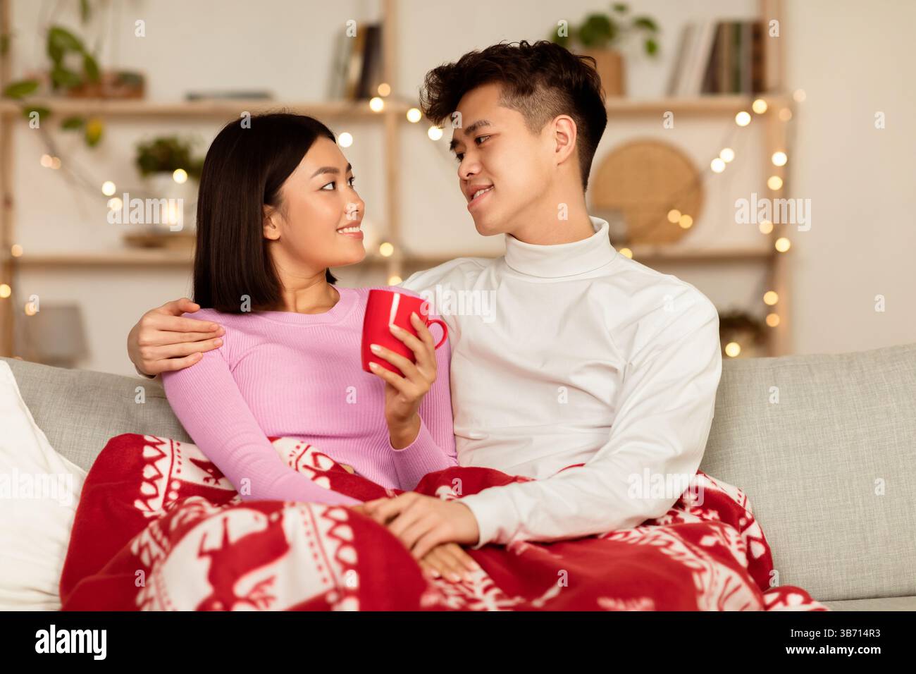 Loving Korean Couple Embracing Drinking Hot Coffee Sitting Indoors ...