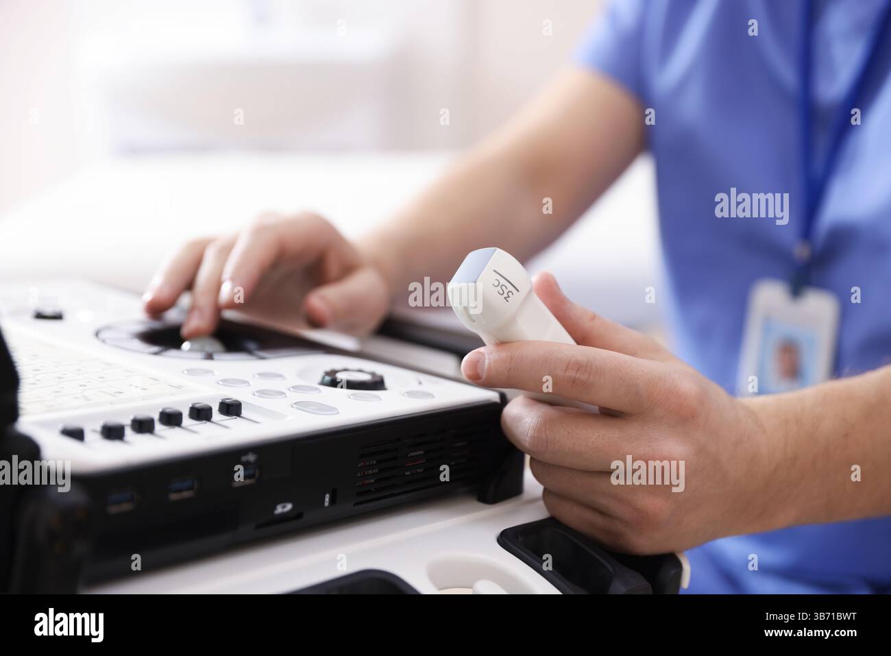 Sonographer with transducer and ultrasound machine in clinic, closeup ...