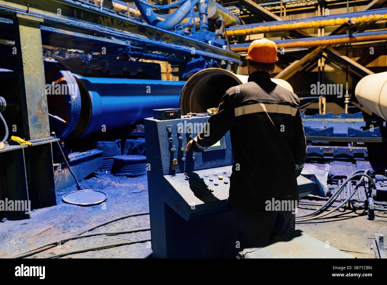 Factory engineer operates pipe painting automatic machine Stock Photo ...