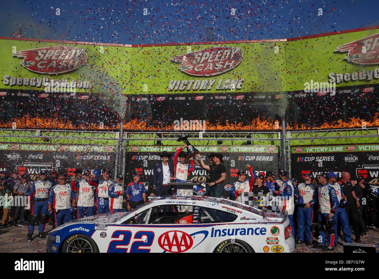 Joey Logano, center, holds the Wurth 400 trophy in Victory Lane after ...