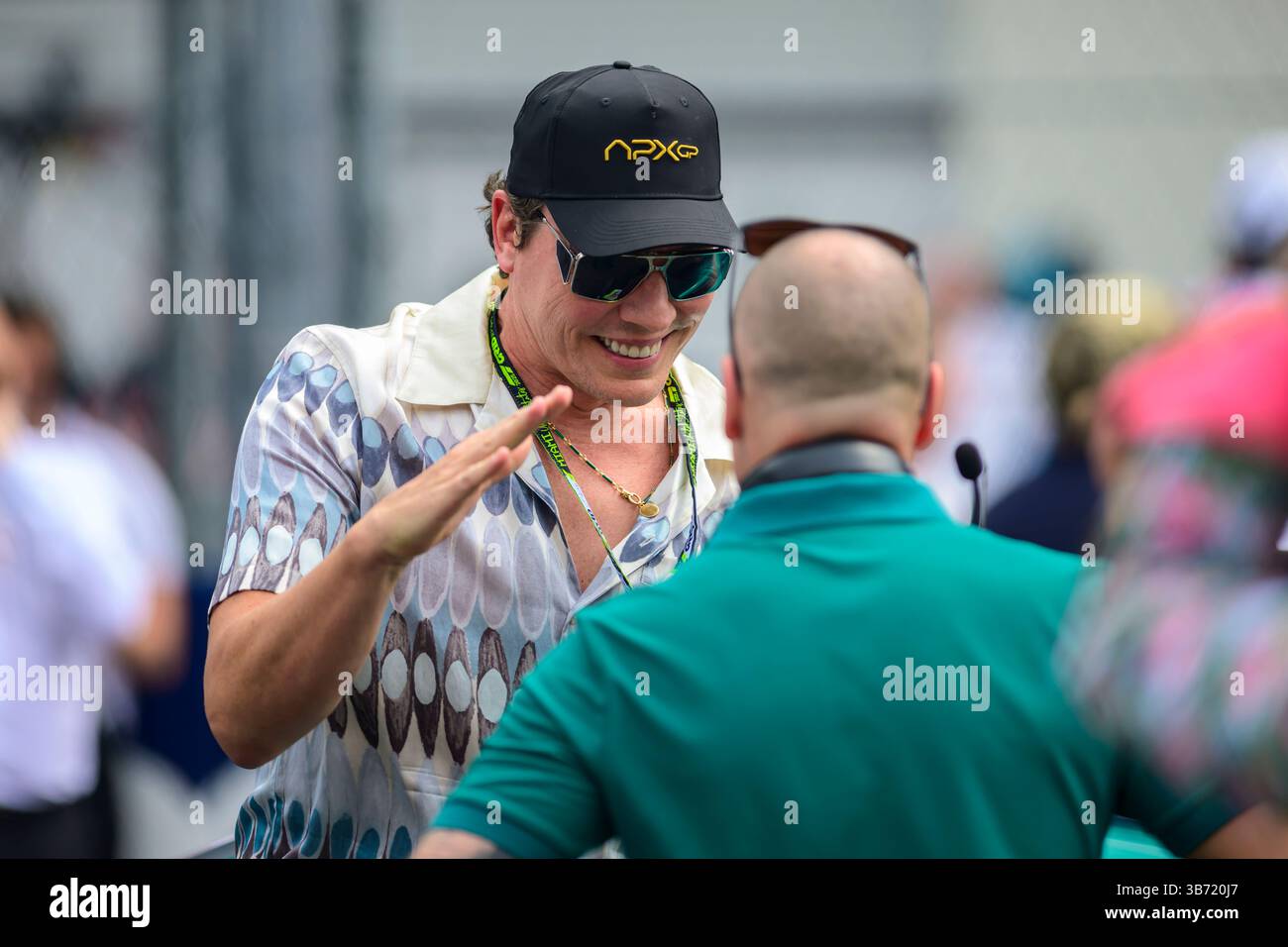 Dutch DJ and record producer Tiësto shakes hands with a safety car ...