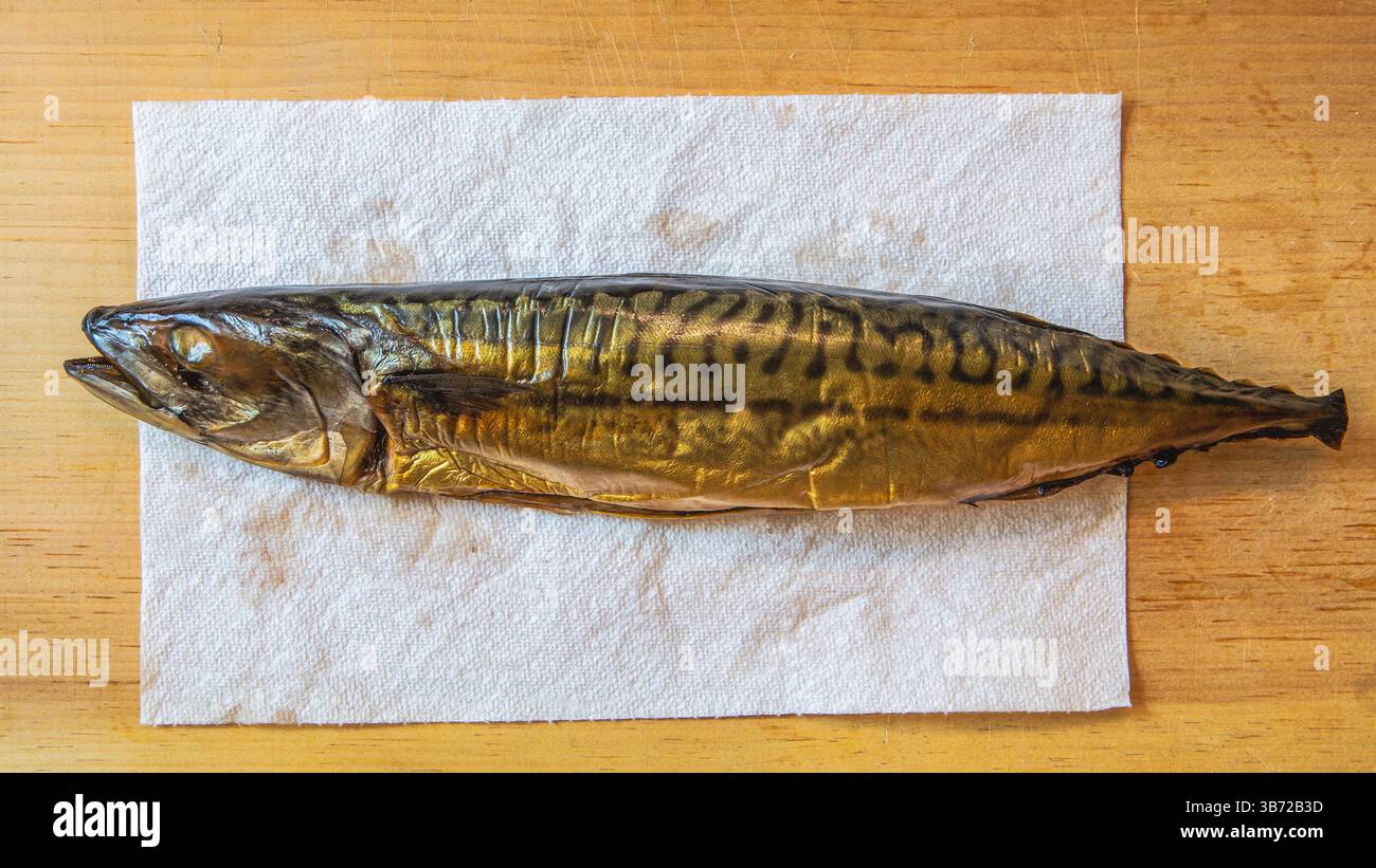 Smoked fish presentation featuring an entire mackerel with glossy ...