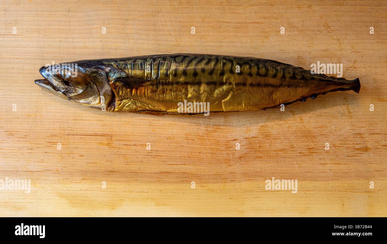 Overhead view of a whole golden-smoked mackerel resting on a rustic ...