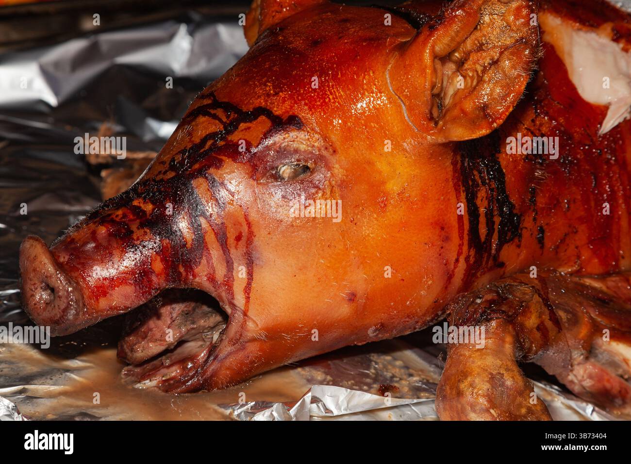 A whole roast pig, close-up, lies on the table and is ready to eat ...