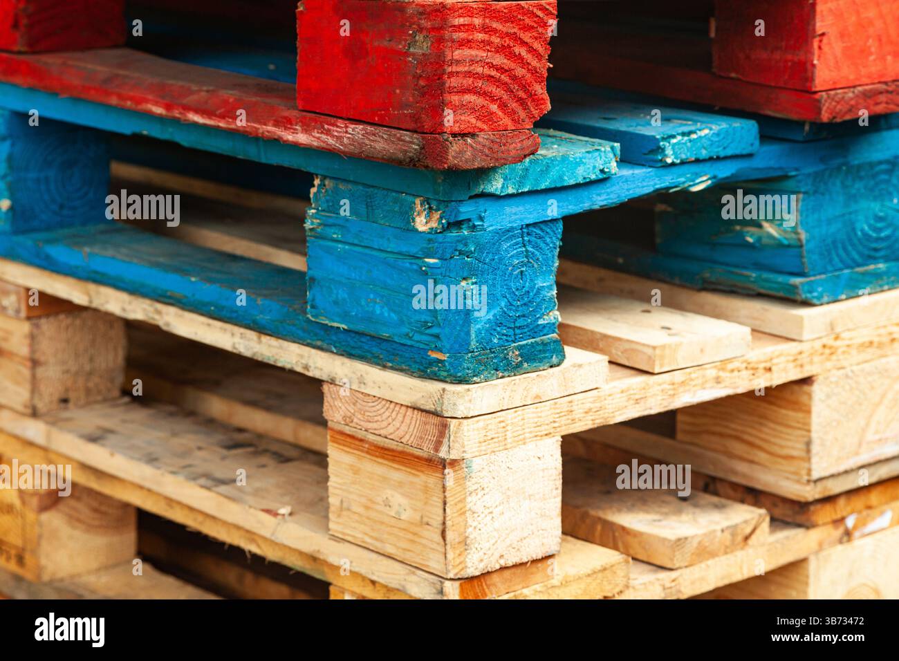 Multi-colored pallets stacked on top of each other Stock Photo - Alamy