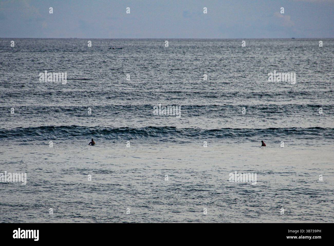 Wide view of two people floating in the middle of the ocean. Peaceful ...