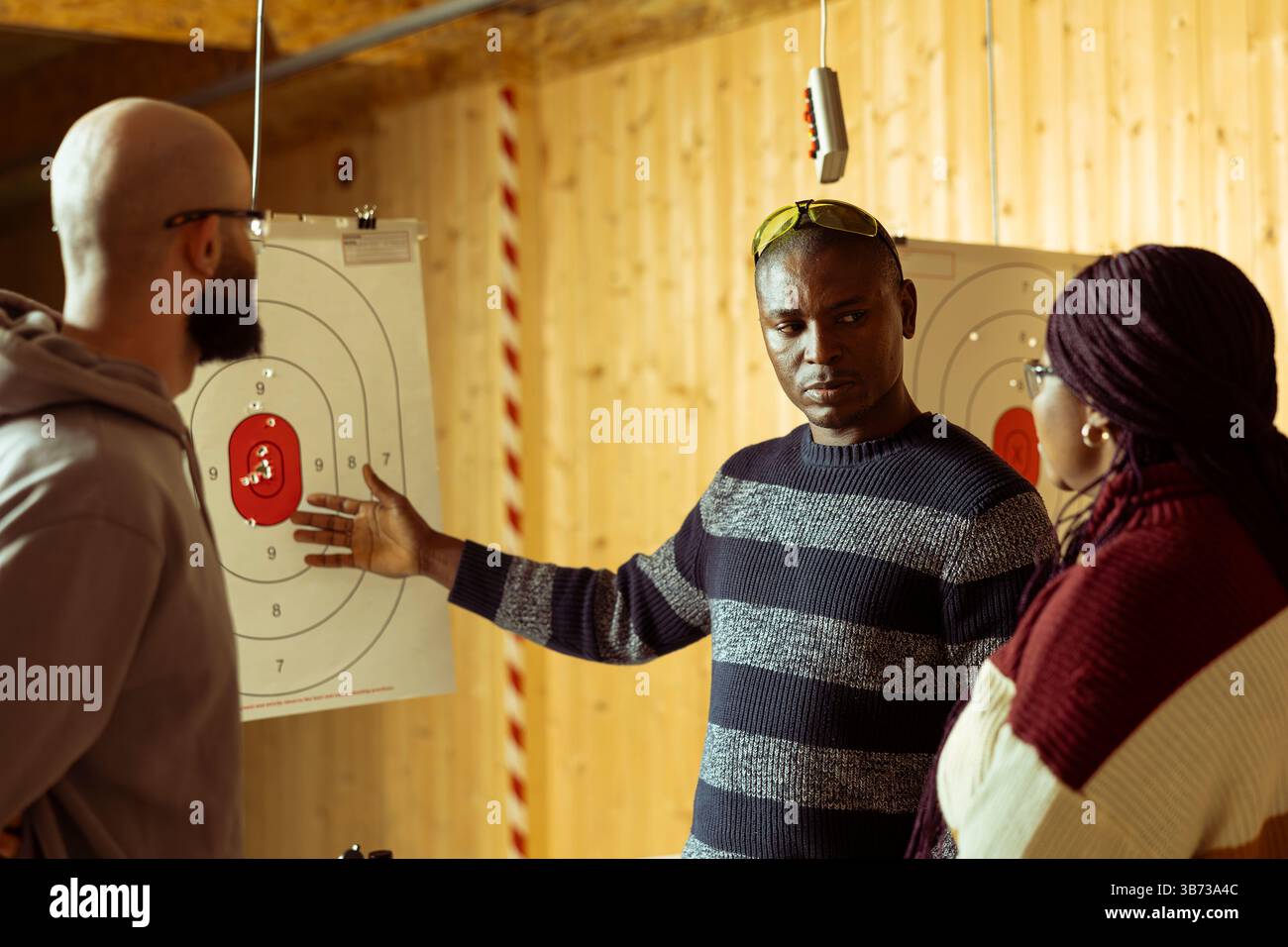 Shooting range safety specialist ensuring clients are operating weapons ...