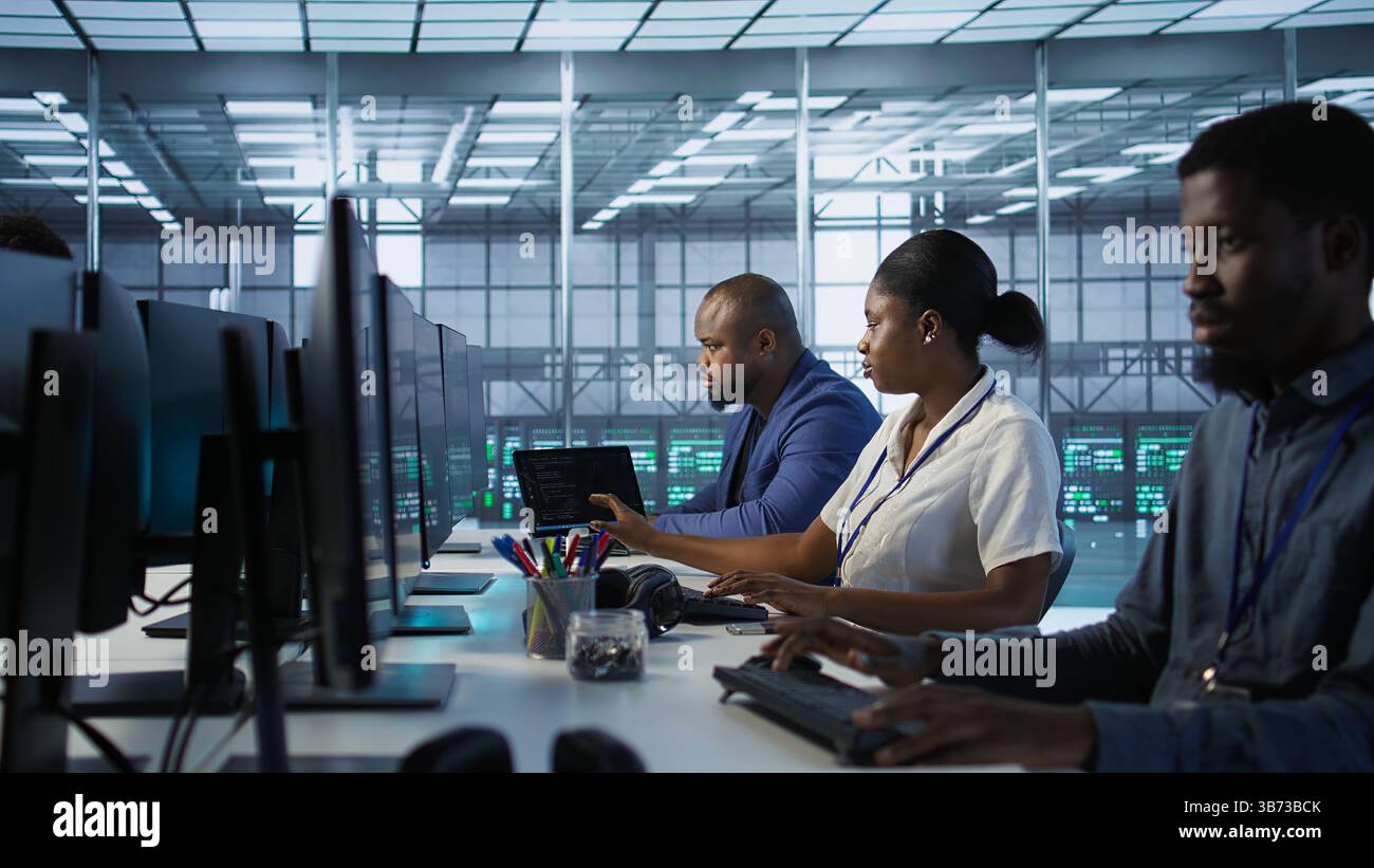 Technicians using computers and tablet in data center, implementing AI systems. Server farm ...