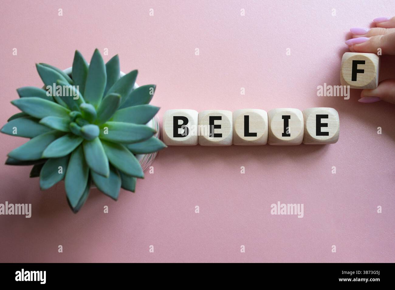 Belief symbol. Concept word Belief on wooden cubes. Businessman hand ...