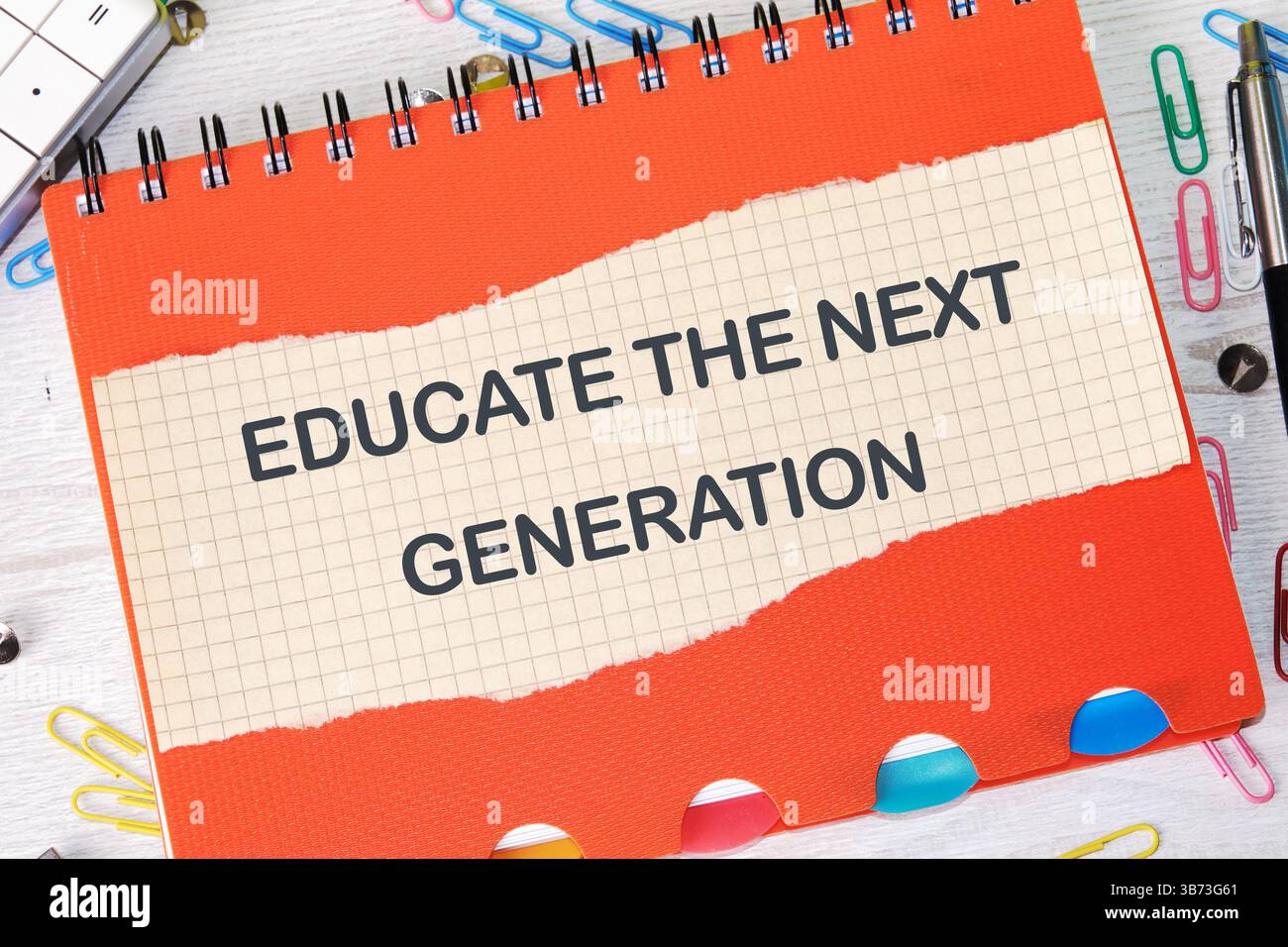 A bright orange notepad displays an inspiring message about educating ...