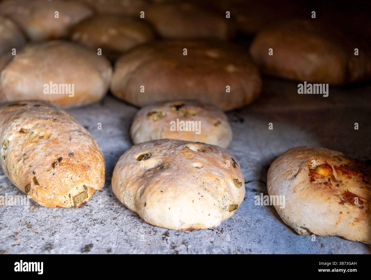 Senior woman making bread in a traditional bread oven, Korucam ...