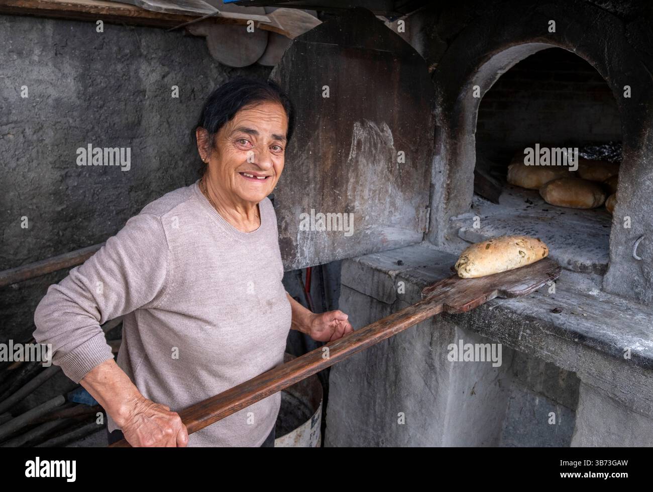 Senior woman making bread in a traditional bread oven, Korucam ...