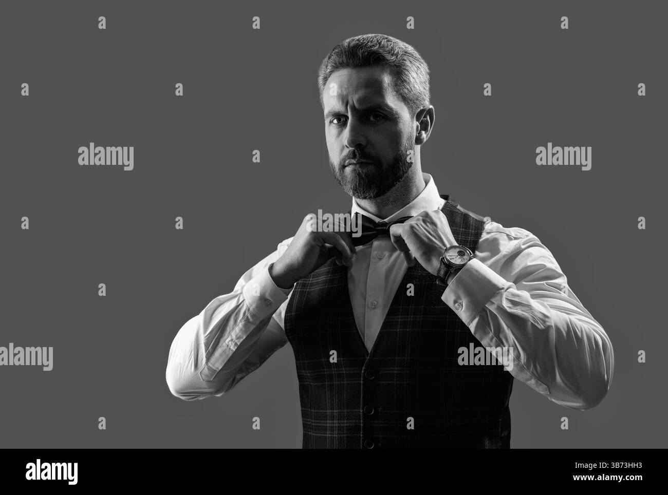 Waiter in bowtie ready to serve. Waitstaff. Tuxedo man in menswear isolated on grey. Charismatic ...