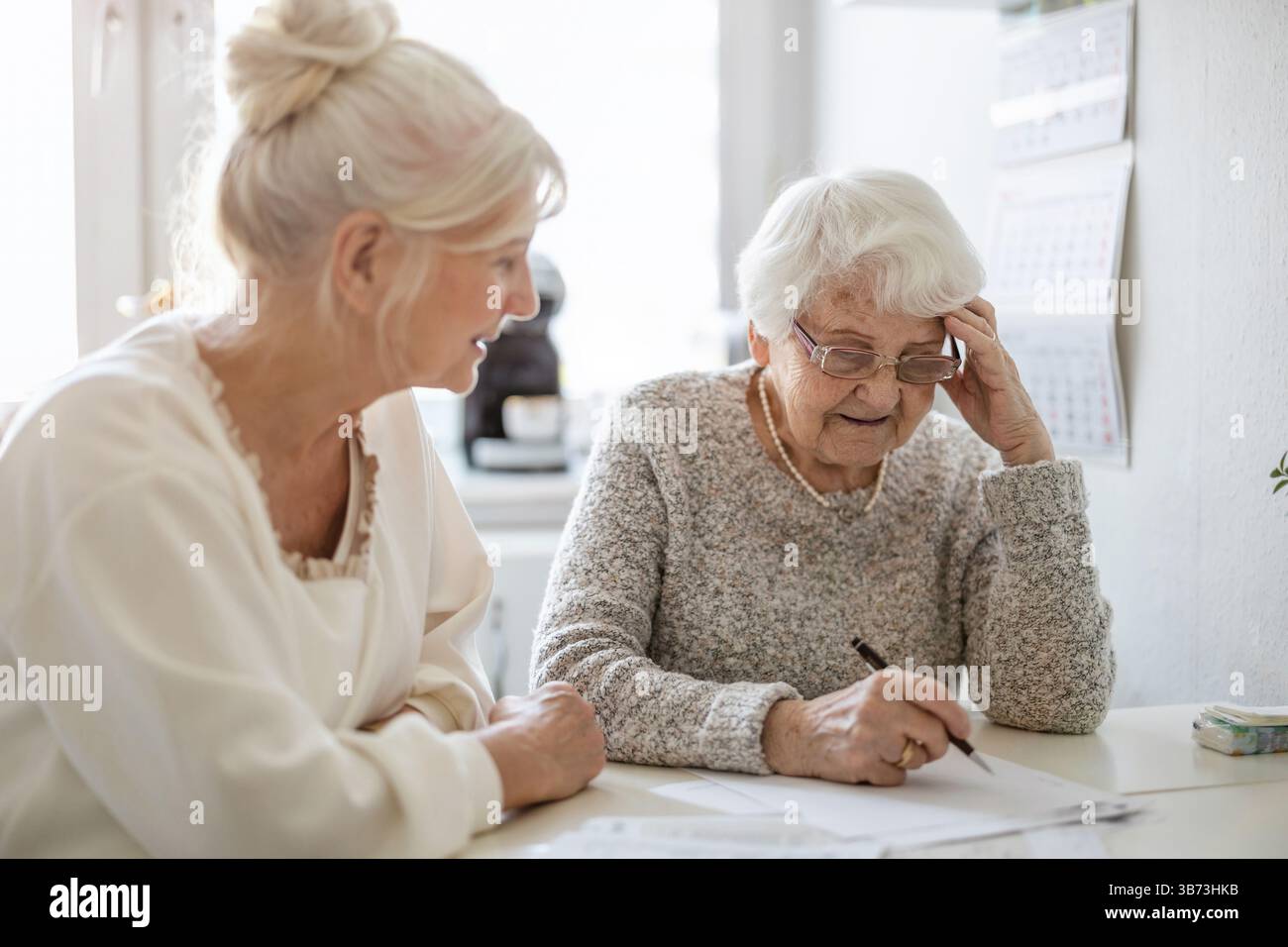 Woman helping her elderly mother preparing financial documents Stock ...