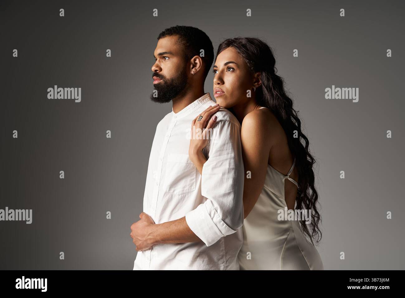 A stylish couple stands close, showcasing elegance and love in a ...