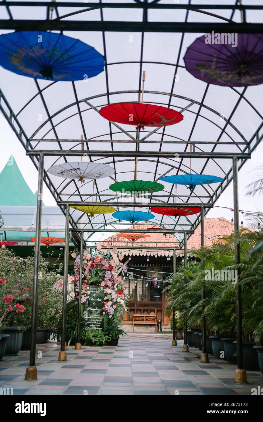 Festive outdoor event space with colorful umbrellas overhead, creating ...