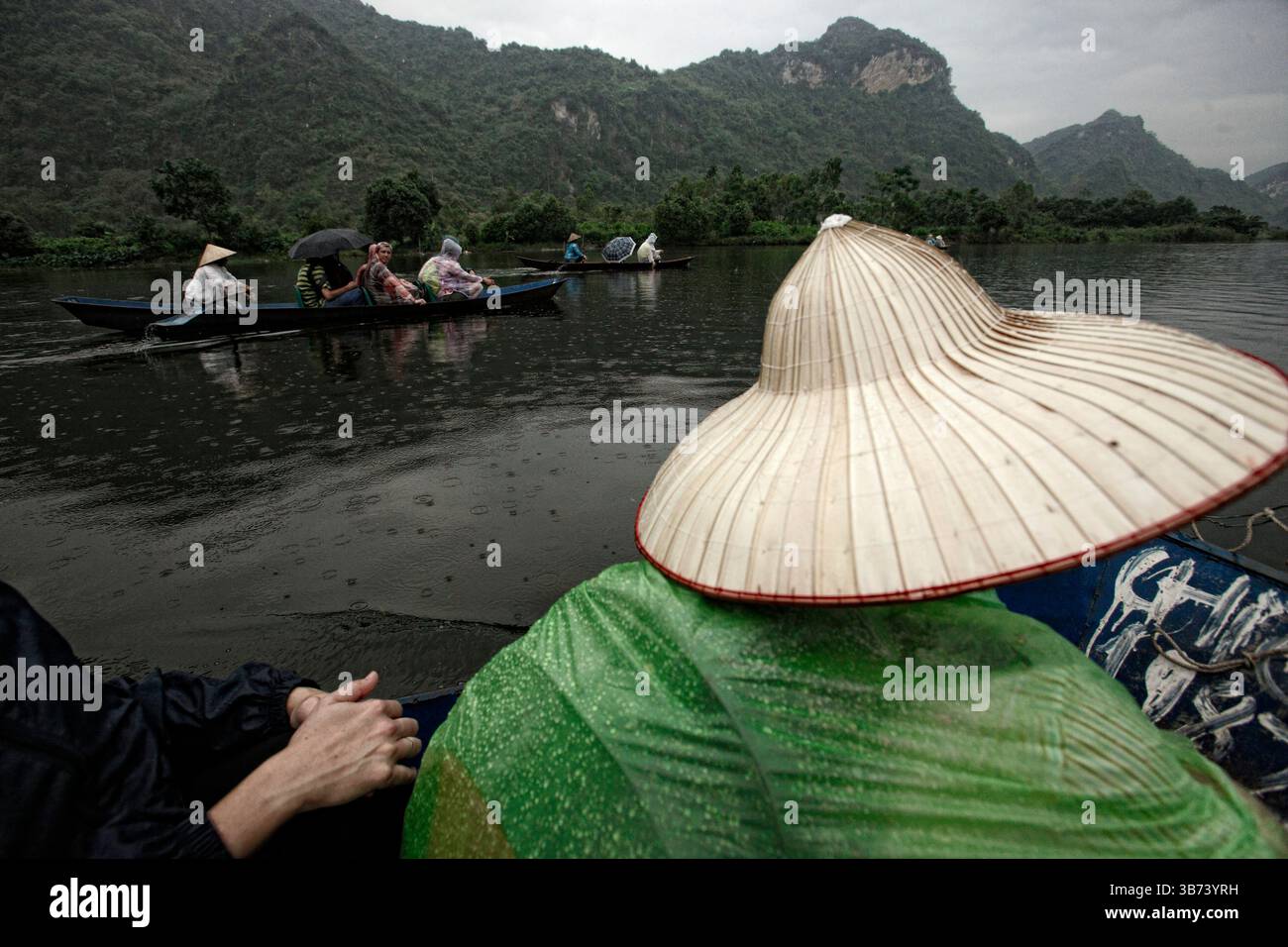 Travelers row on a rainy day in Hanoi Bay Stock Photo - Alamy