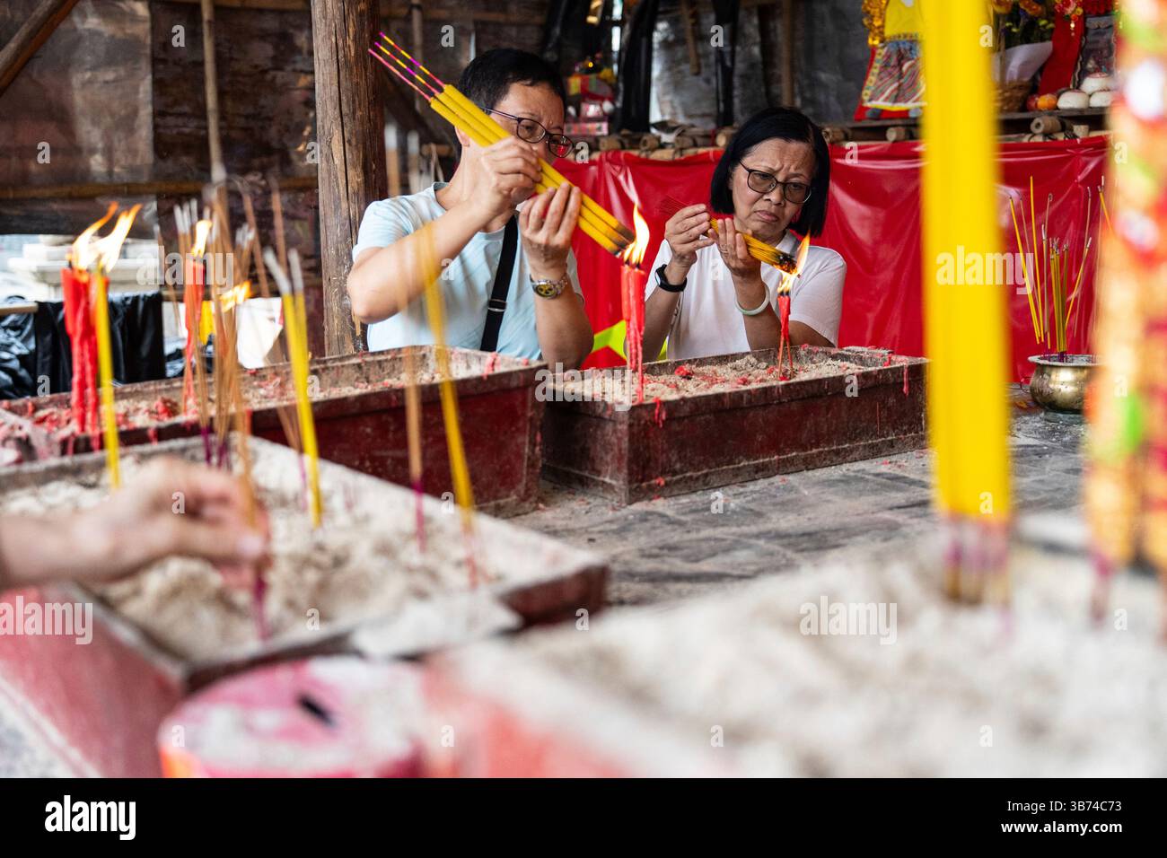 Worshippers burn incense at a temple during the Bun Festival in Cheung ...