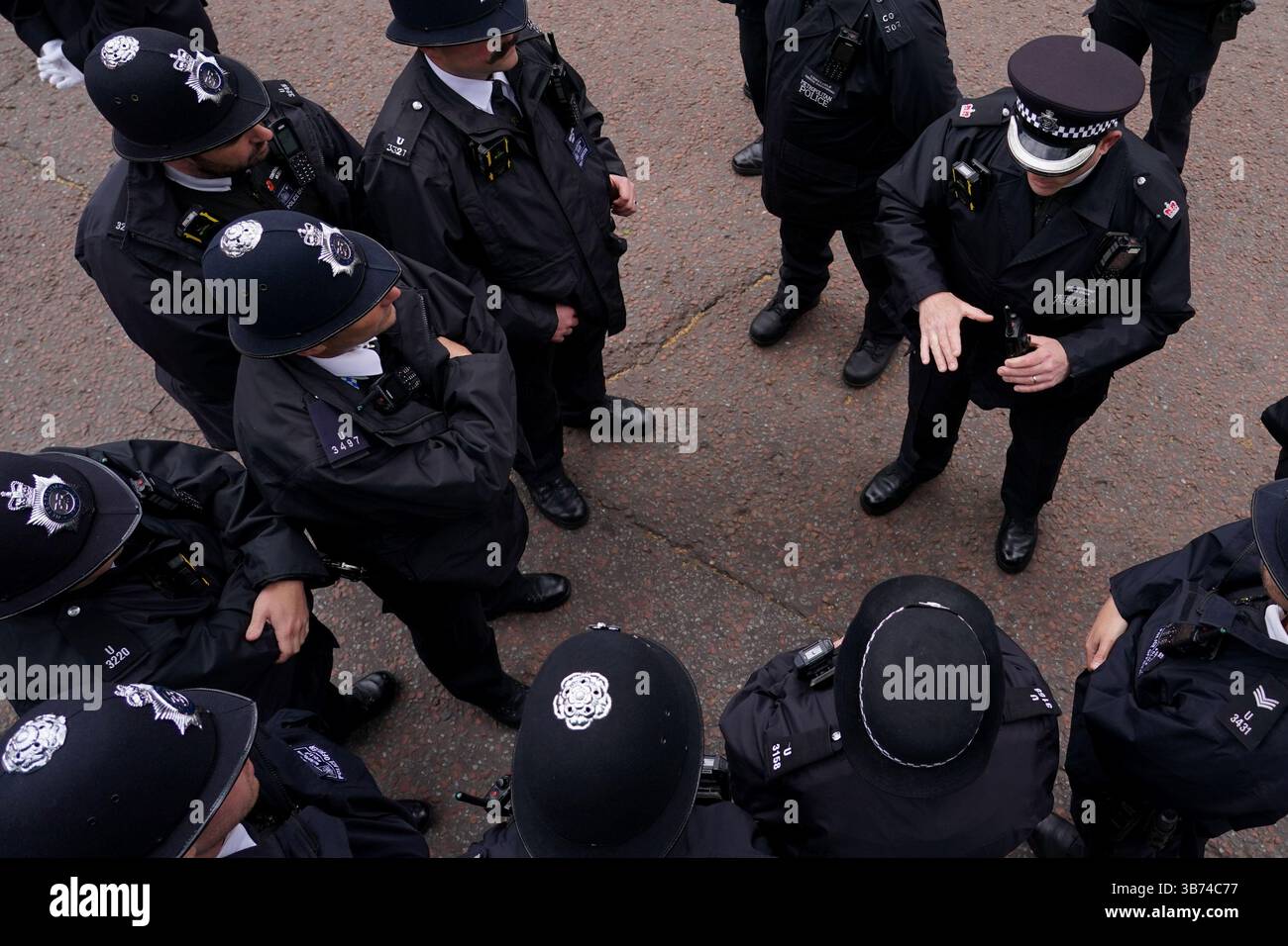 Police officers are briefed ahead of a military procession marking the ...
