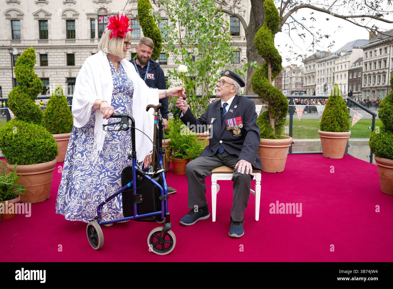 Second World War veteran Alan Kennett gives a peace rose to his ...