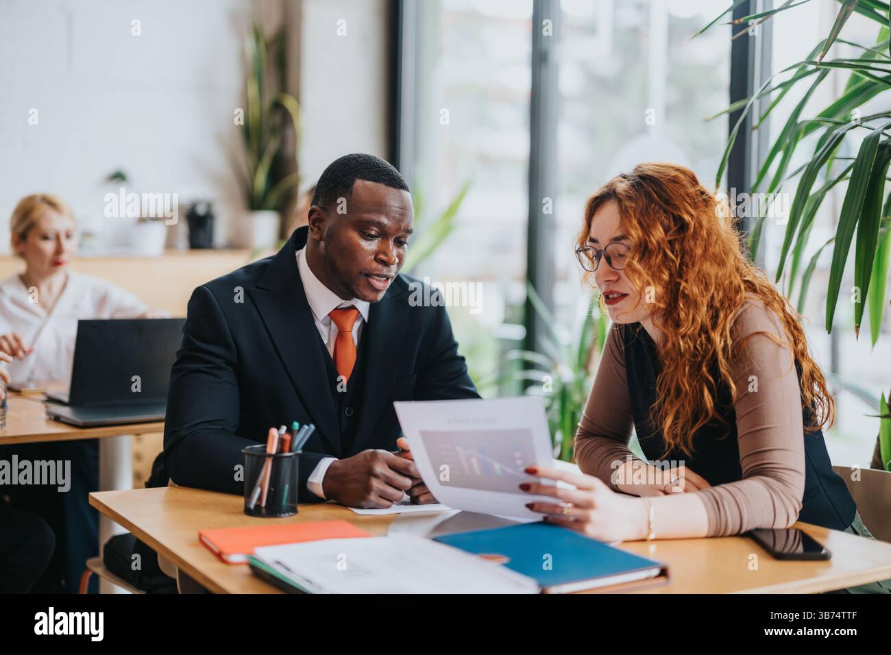 Two people discussing documents in a collaborative co working space ...