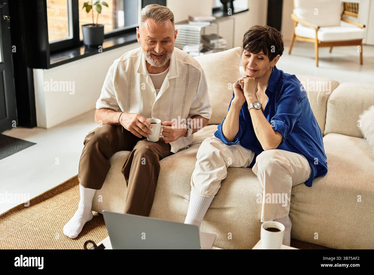 A joyful couple shares laughter and a cozy moment together at home ...