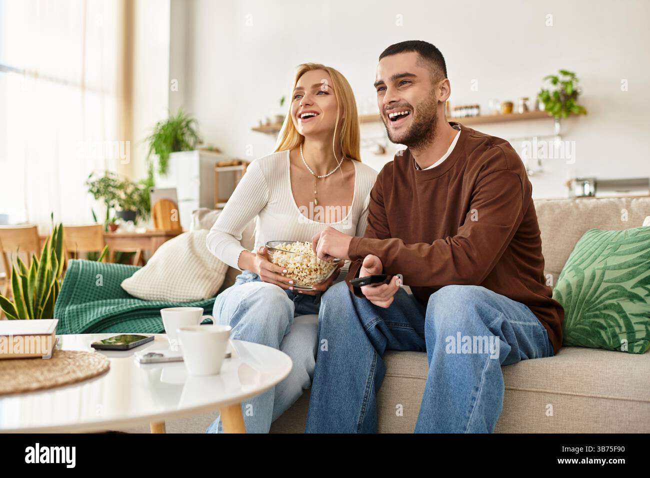 A couple shares laughter and snacks while relaxing on a comfortable ...