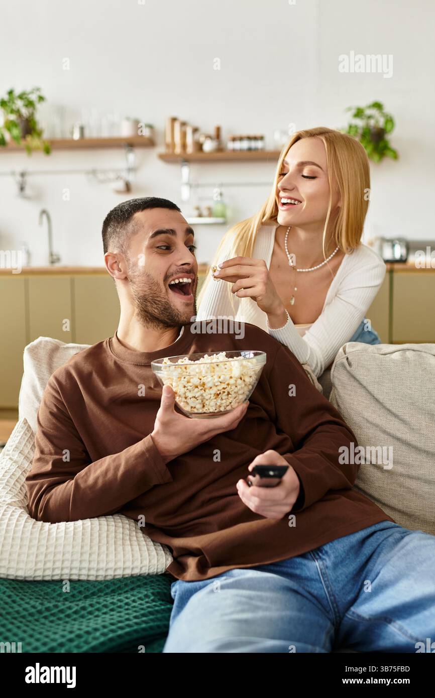 Loving couple shares a joyful moment at home, having fun while watching ...