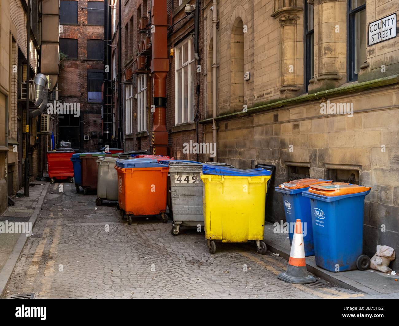 Row of colourful wheelie bins on a Manchester back street. England ...