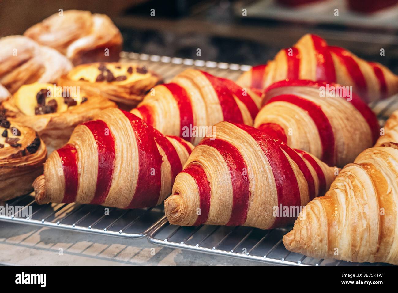 A tempting display of classic and raspberry croissants and tarts in a ...