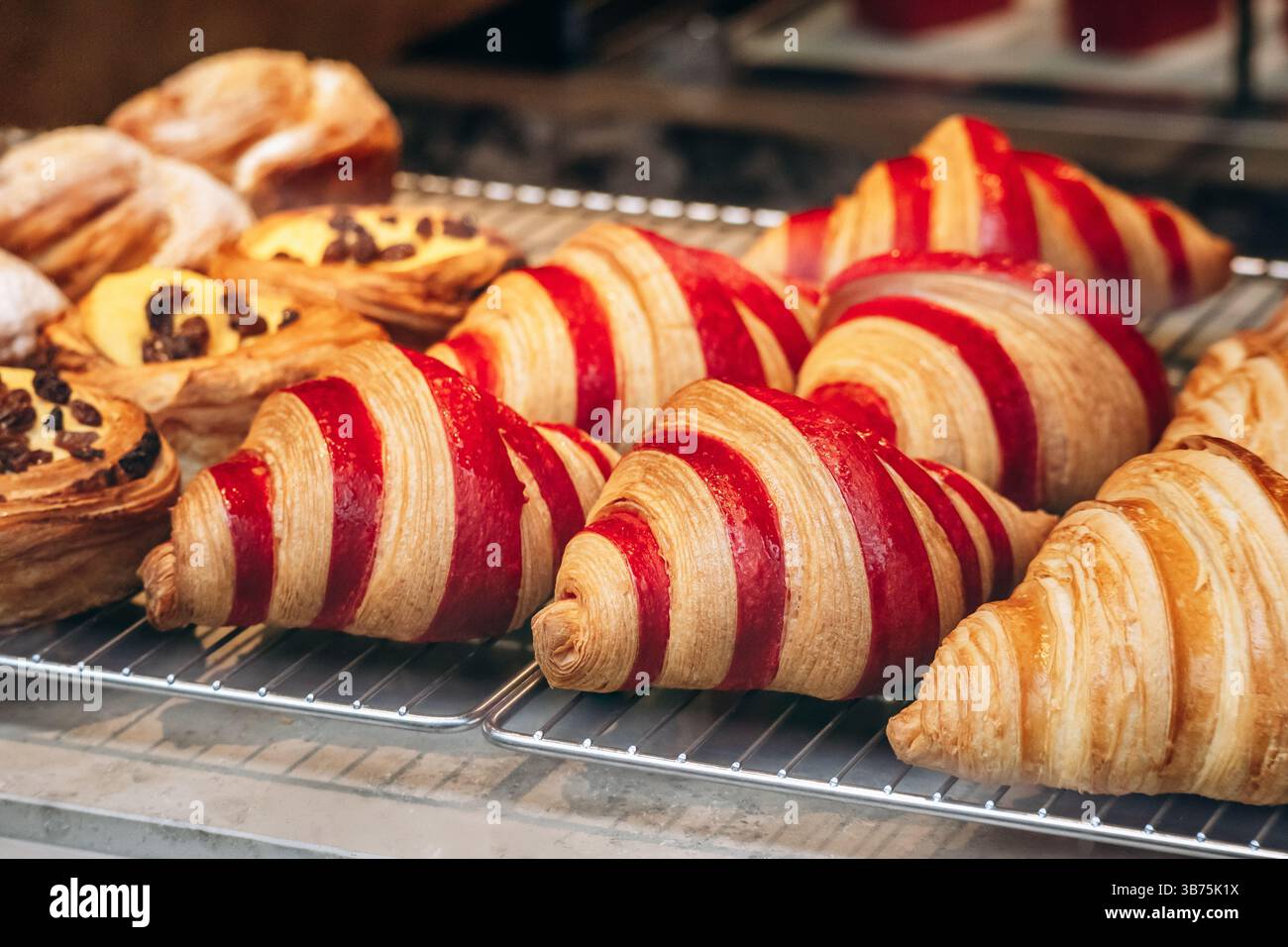 A tempting display of classic and raspberry croissants and tarts in a ...
