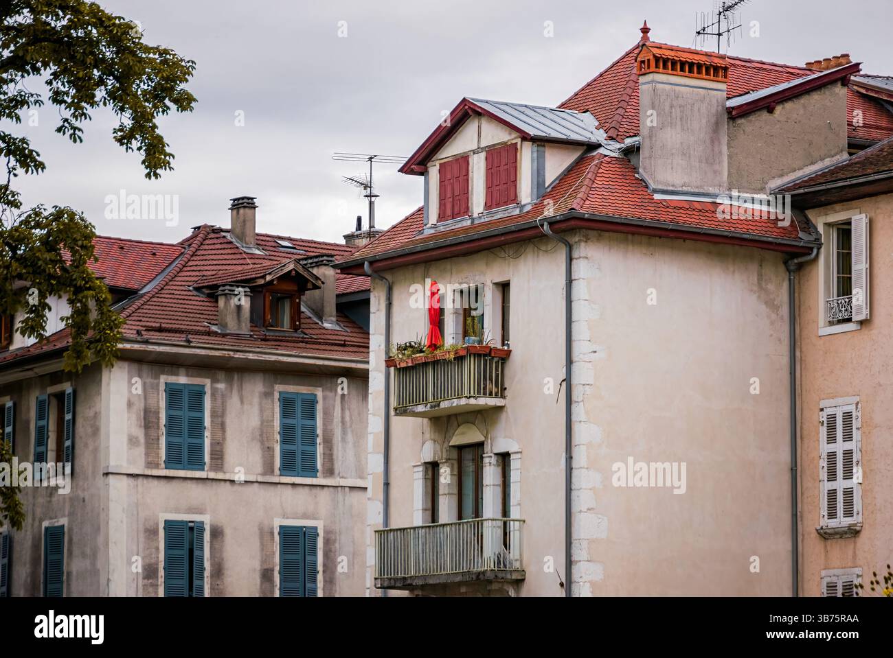 Balcony with red umbrella on old French building Stock Photo - Alamy