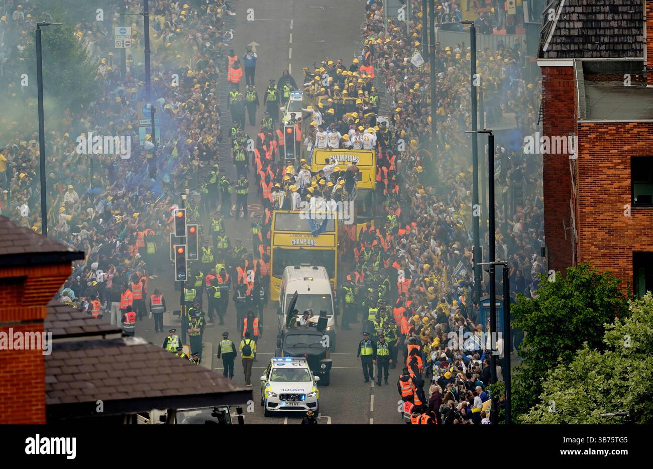 Fans line the street as the Leeds United parade buses enter the city ...