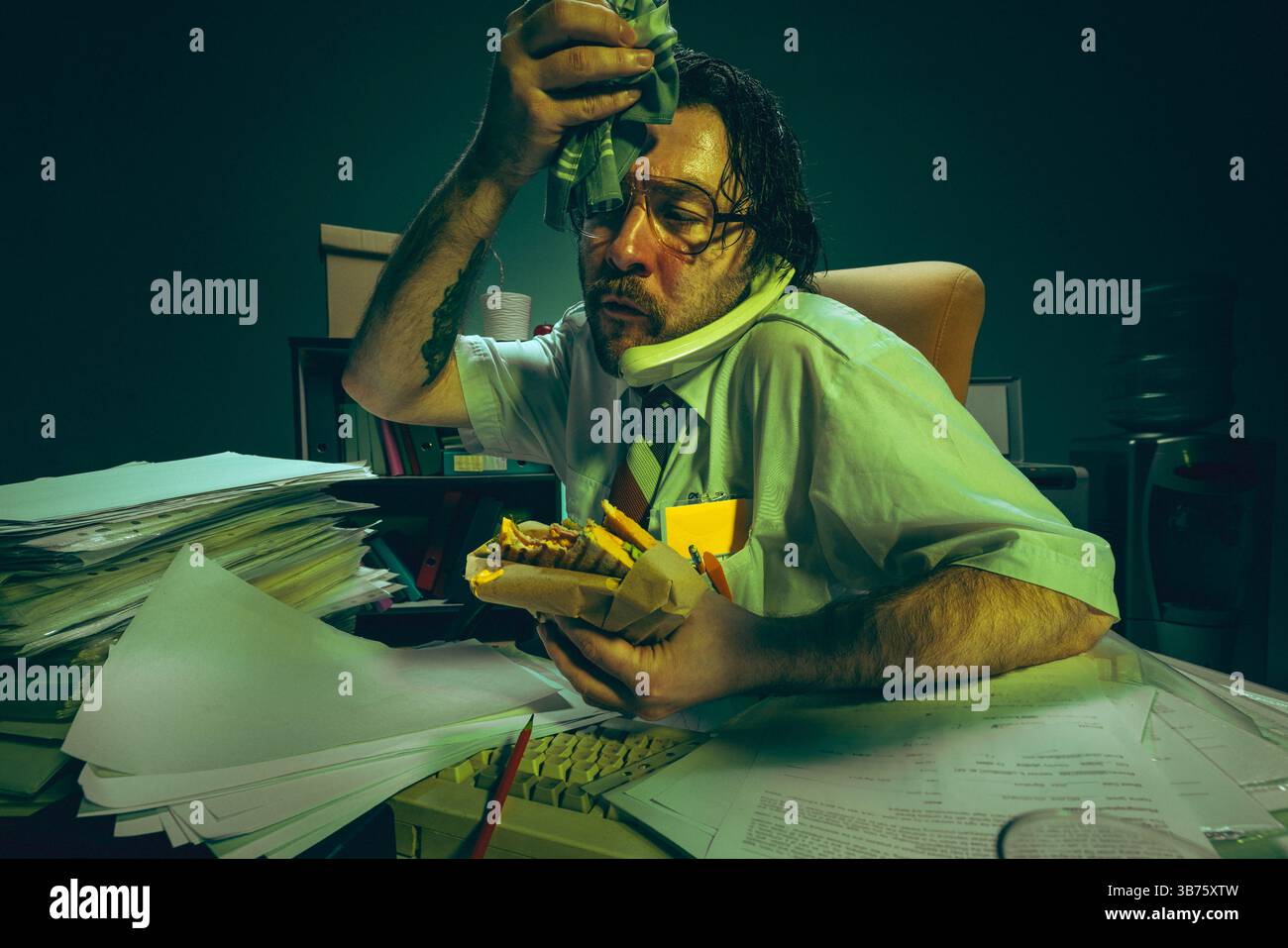 Office man sweating, holding sandwich, talking on phone with papers on ...