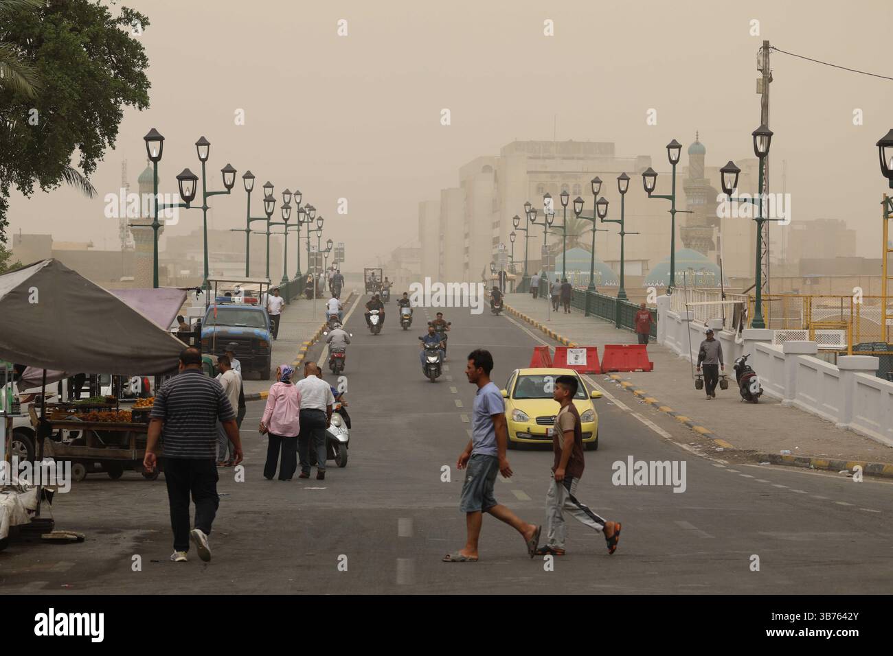 Baghdad, Iraq. 5th May, 2025. People walk in dense dust in Baghdad ...