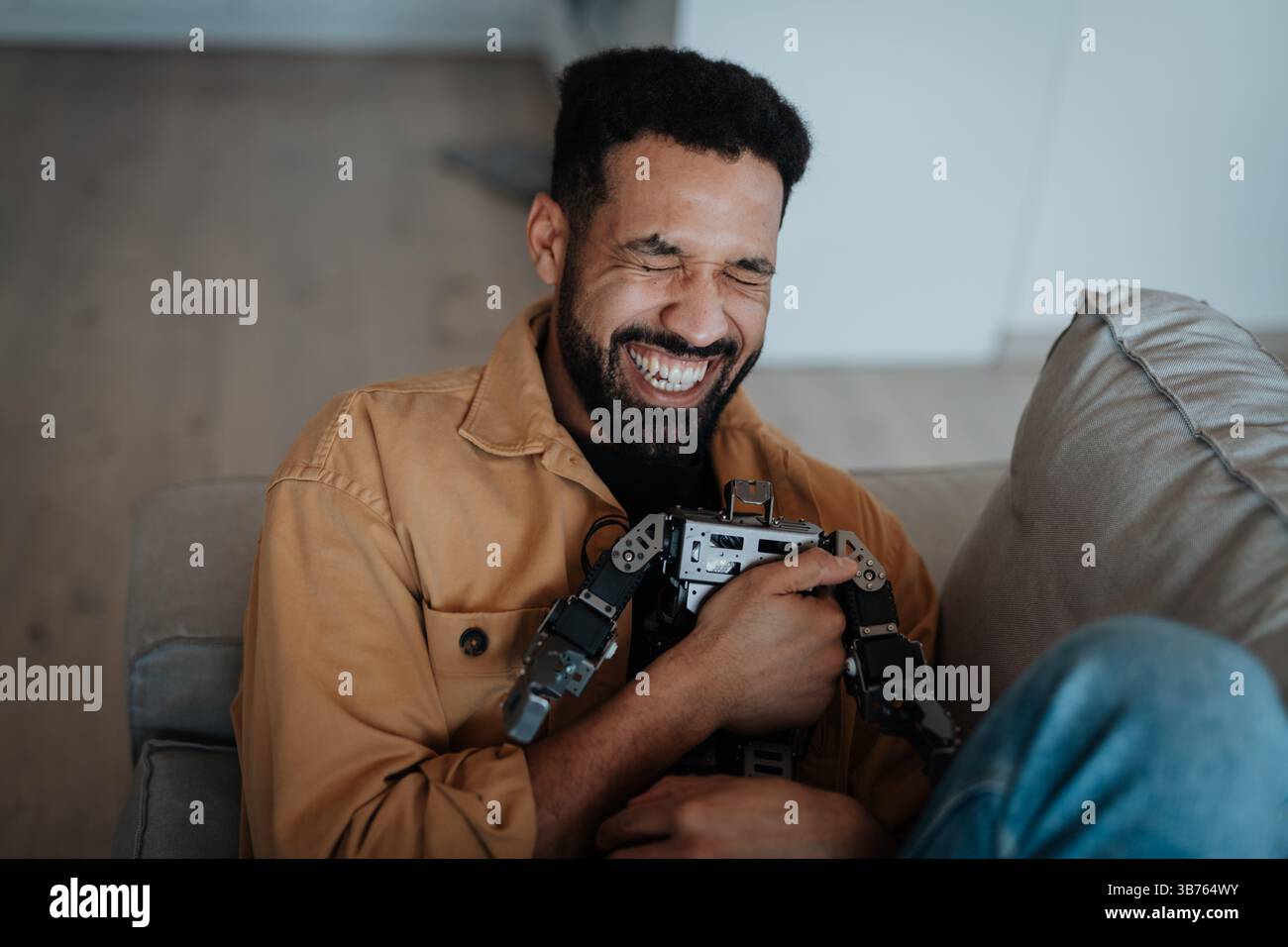 Handsome man hugging small robot like real friend Stock Photo - Alamy