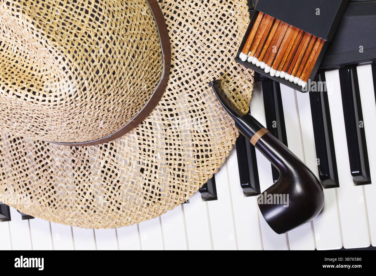 Detail of piano keyboard, straw hat and luxury pipe Stock Photo - Alamy