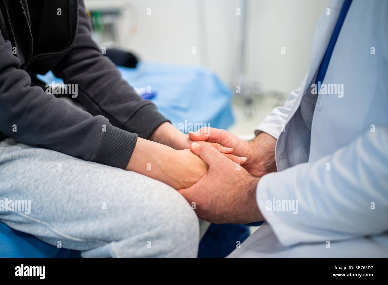Close up of compassionate doctor holding hands of anxious teenage ...