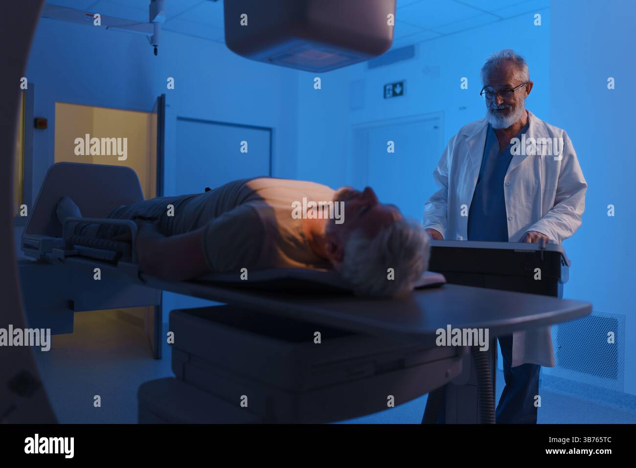 Male patient undergoing X-ray examination using tilting radiographic ...