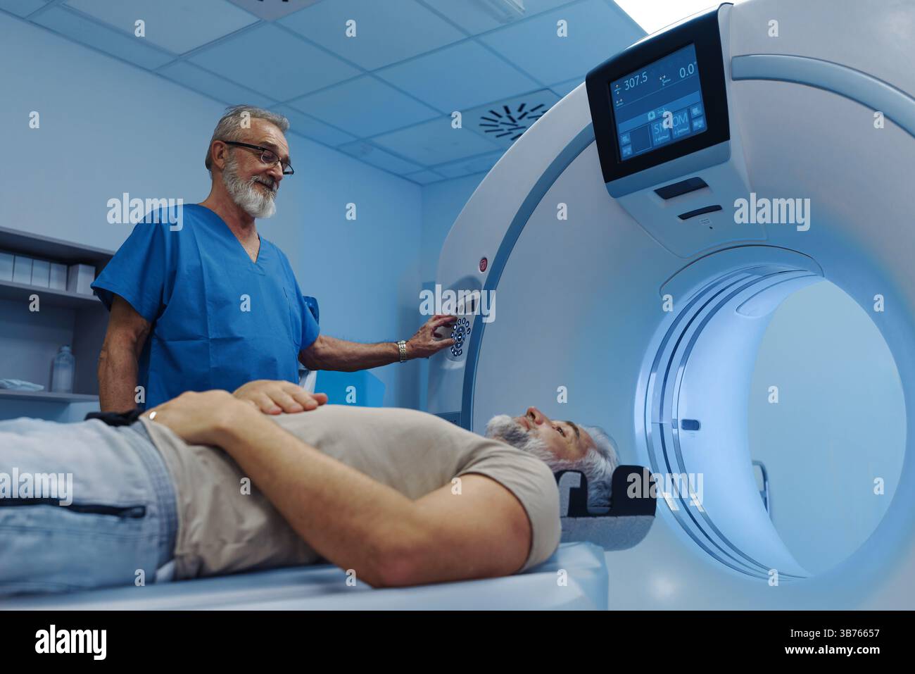 Male patient undergoing X-ray examination using tilting radiographic ...